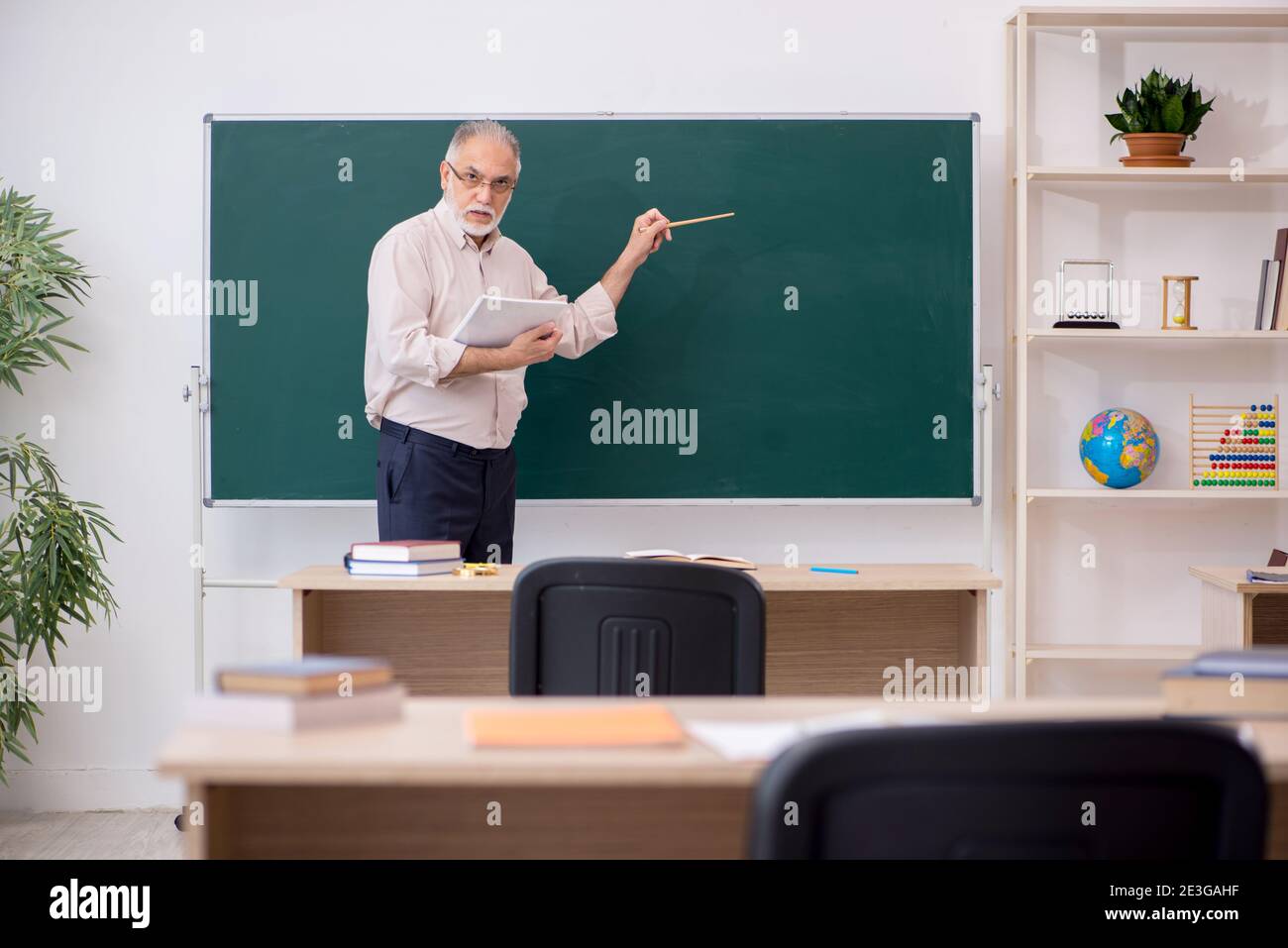 Old teacher in front of blackboard Stock Photo - Alamy
