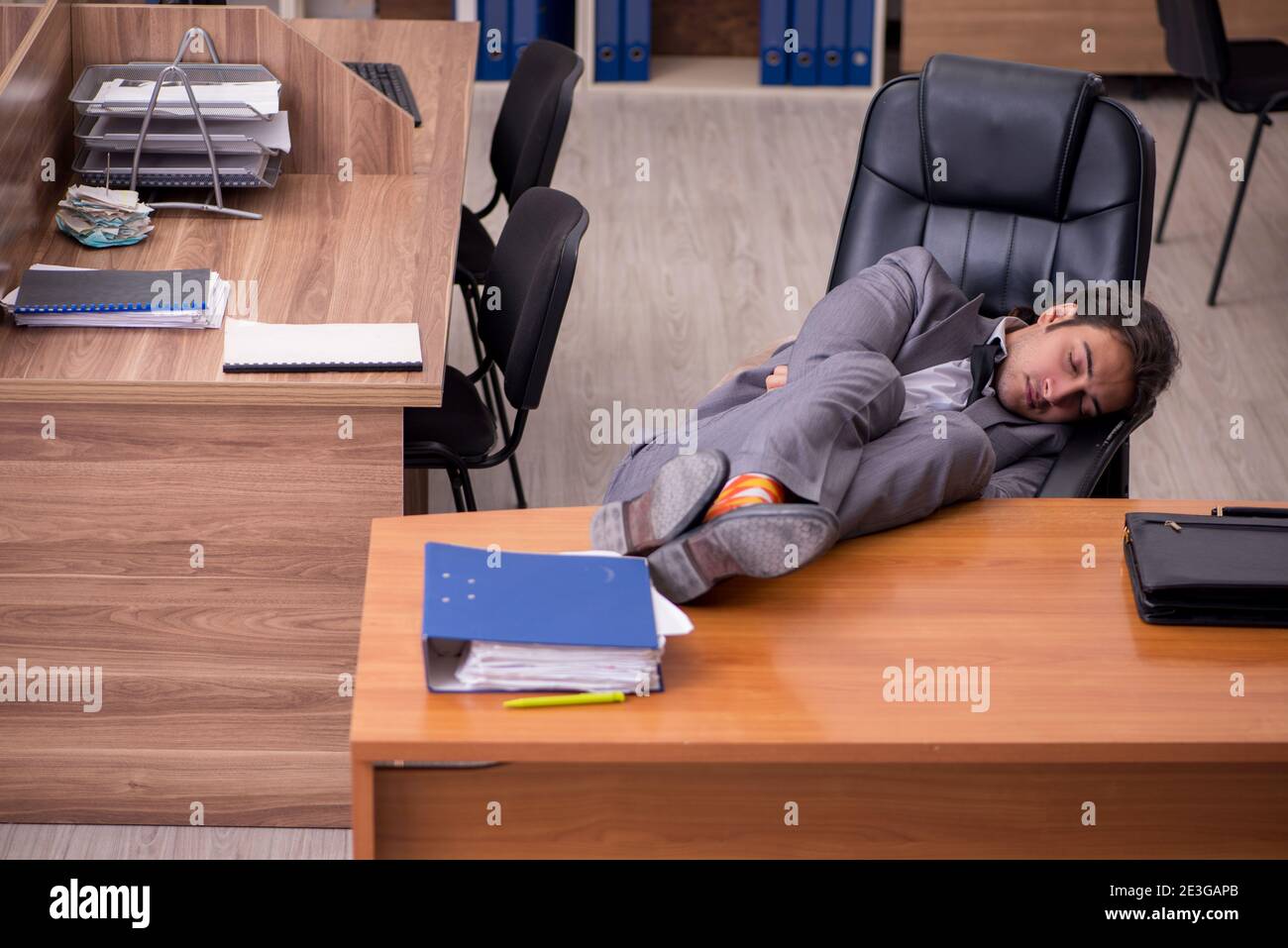 Young employee sleeping at workplace Stock Photo - Alamy
