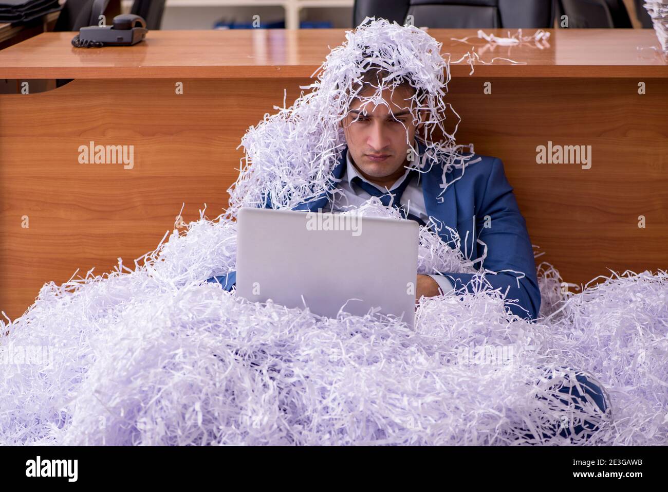 Young male employee cutting papers in the office Stock Photo - Alamy