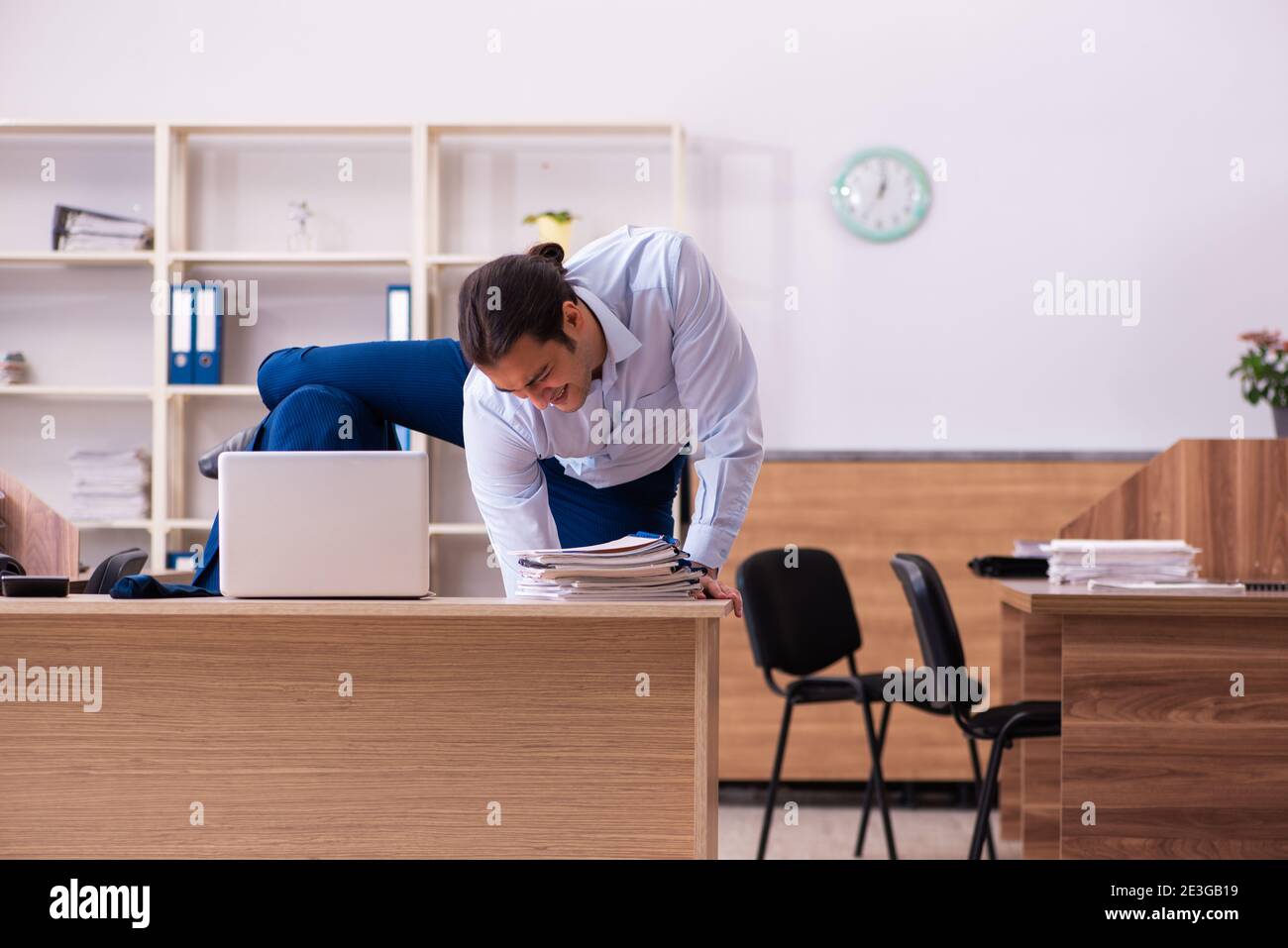 Young employee doing physical exercises at workplace Stock Photo - Alamy