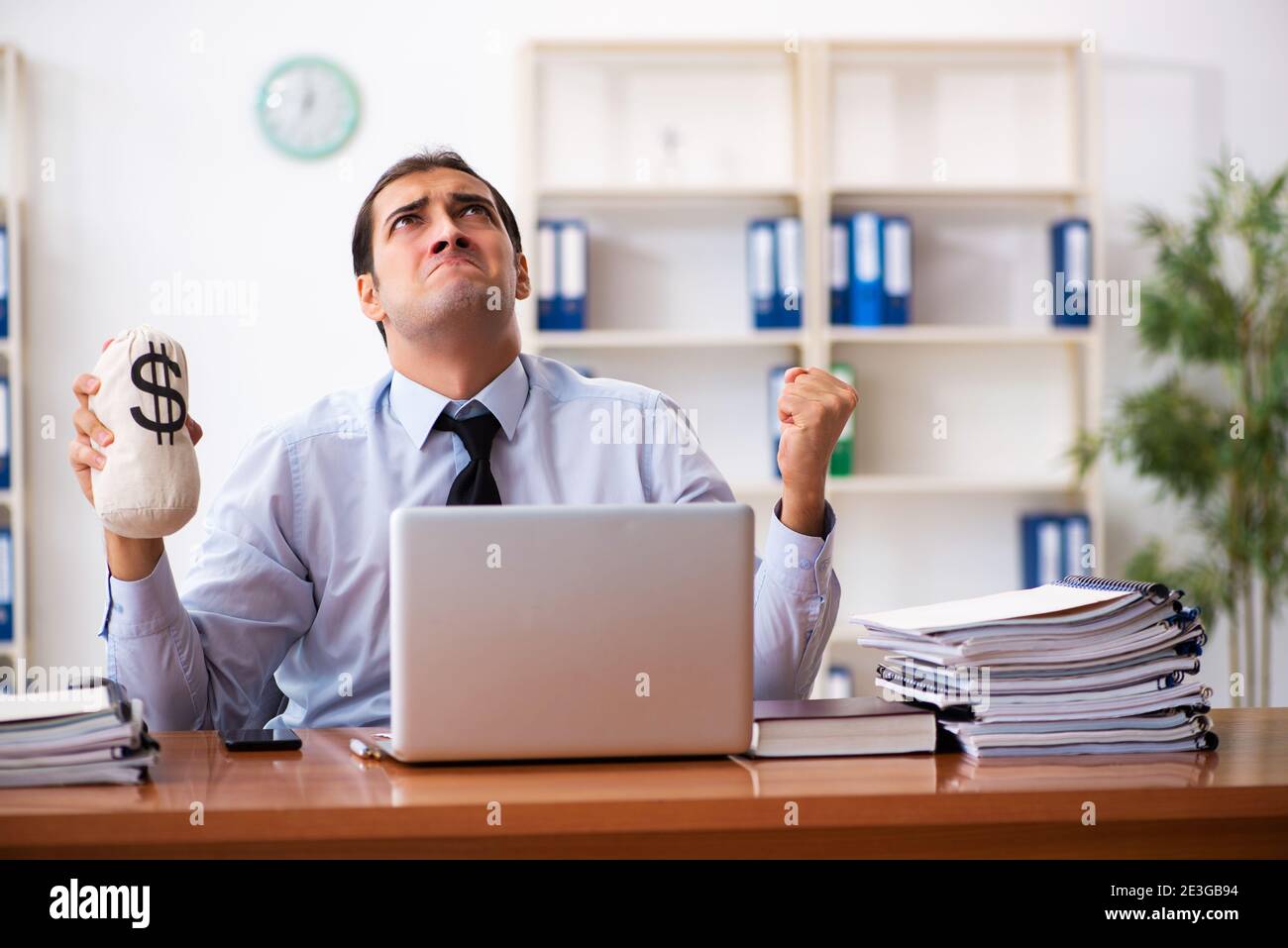 Young employee in payment concept at workplace Stock Photo - Alamy