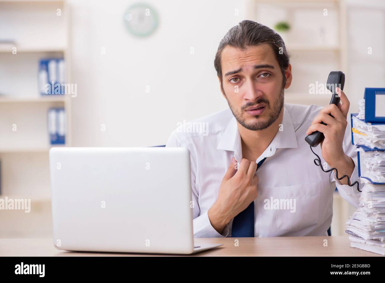 Businessman unhappy with excessive work in the office Stock Photo - Alamy