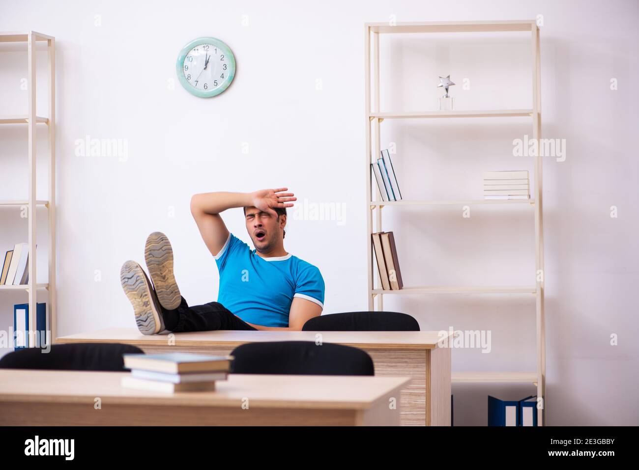 Exhausted student preparing for the exams in the classroom Stock Photo ...
