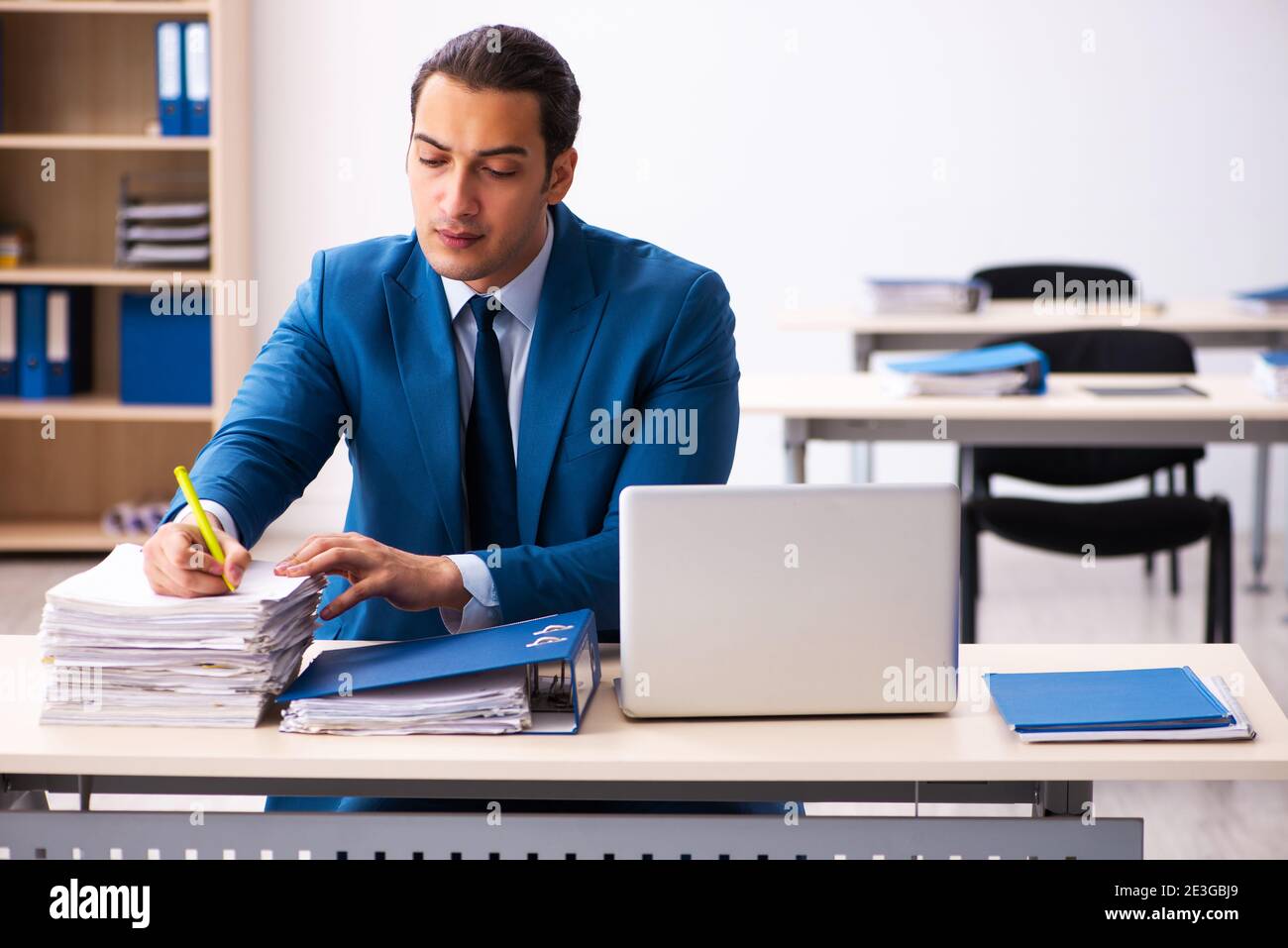 Young male employee taking notes in the office Stock Photo - Alamy
