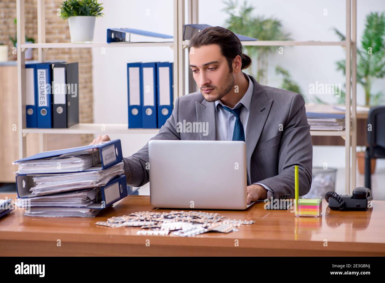 Male sick employee suffering at workplace Stock Photo - Alamy
