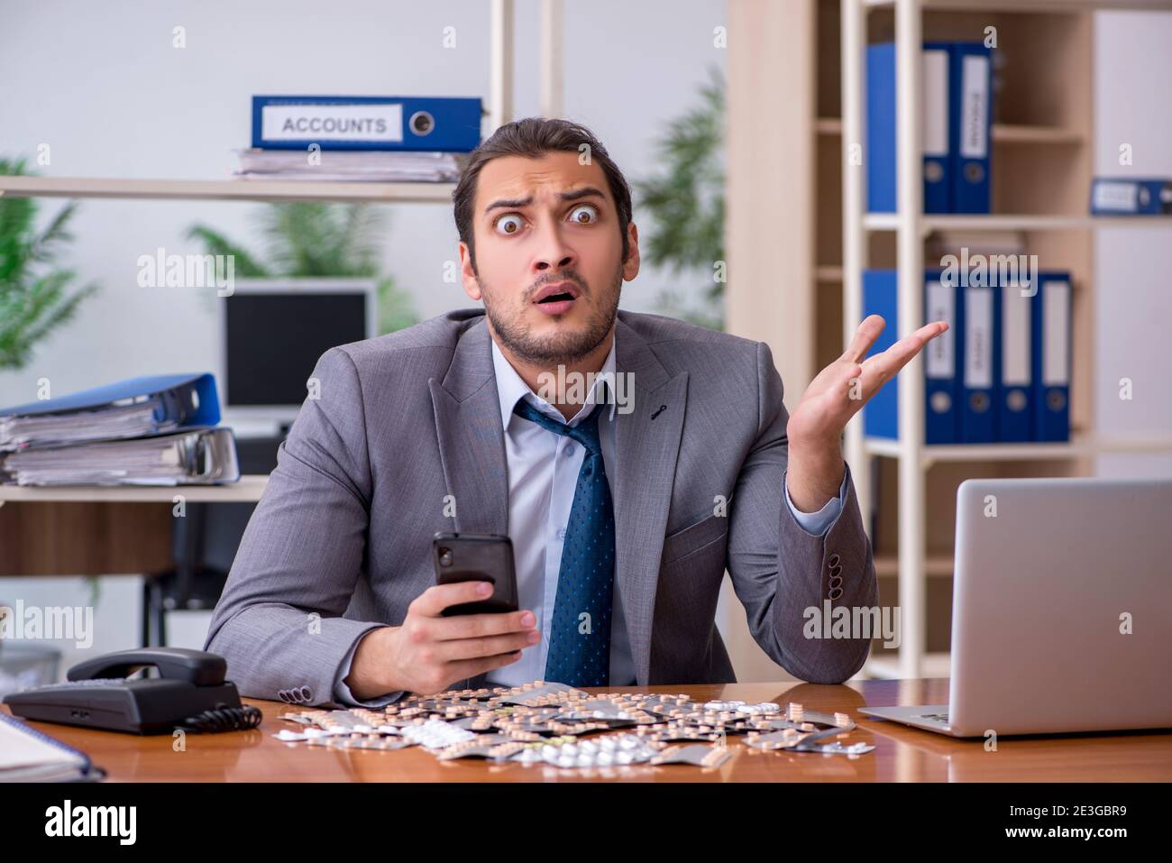 Male sick employee suffering at workplace Stock Photo - Alamy