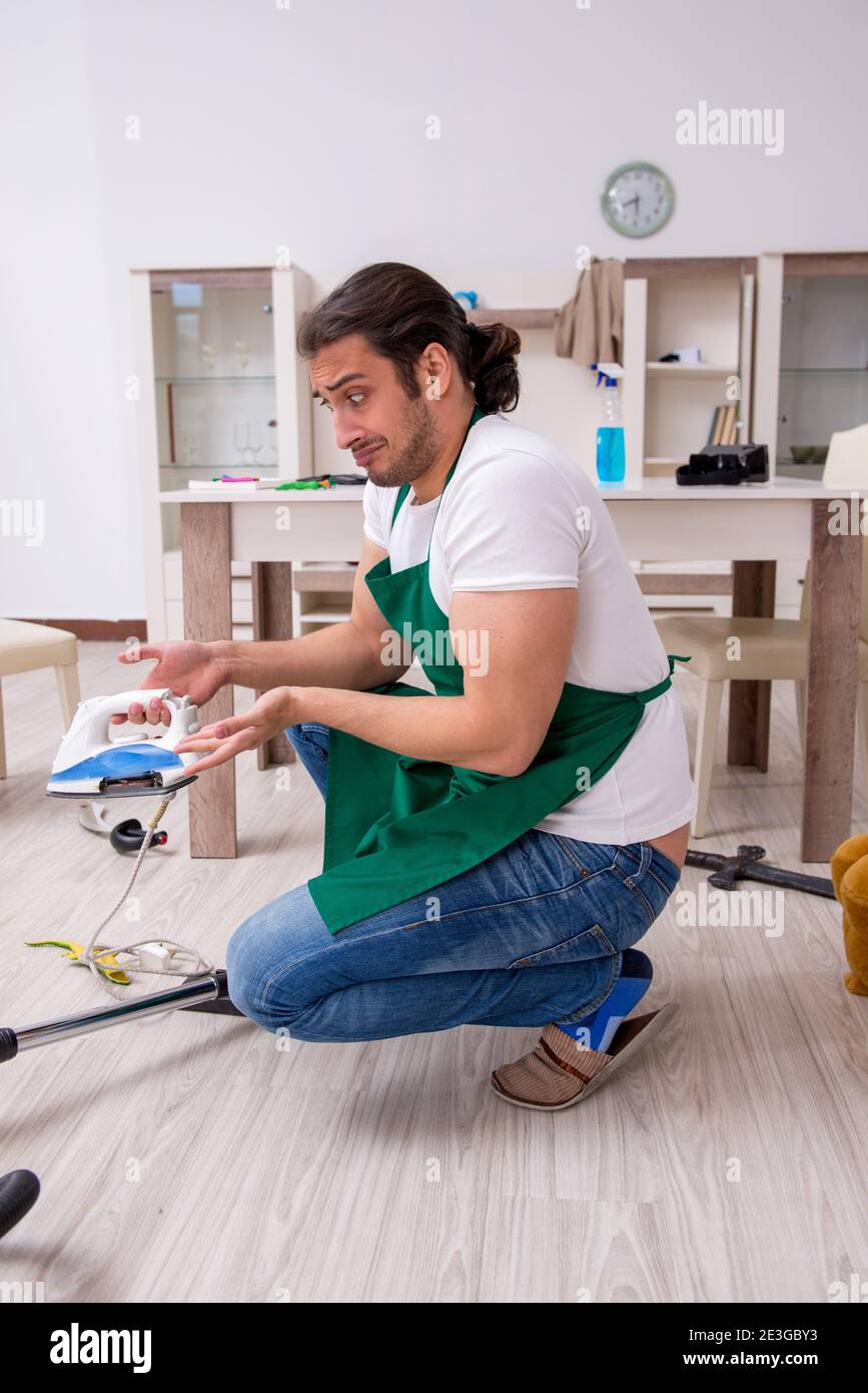 Young contractor cleaning the flat after kids' party Stock Photo - Alamy
