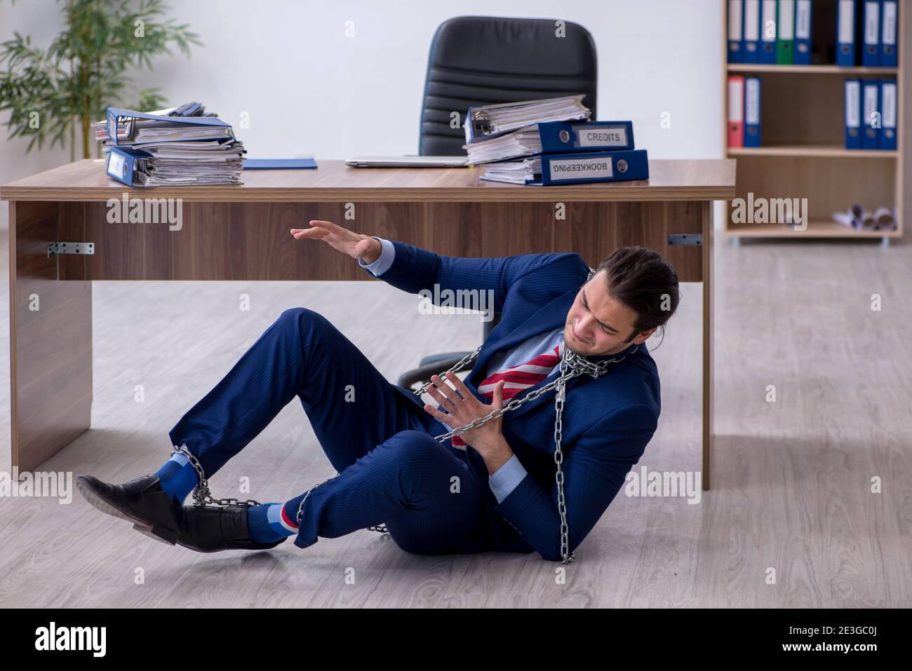 Chained employee unhappy with excessive work in the office Stock Photo ...