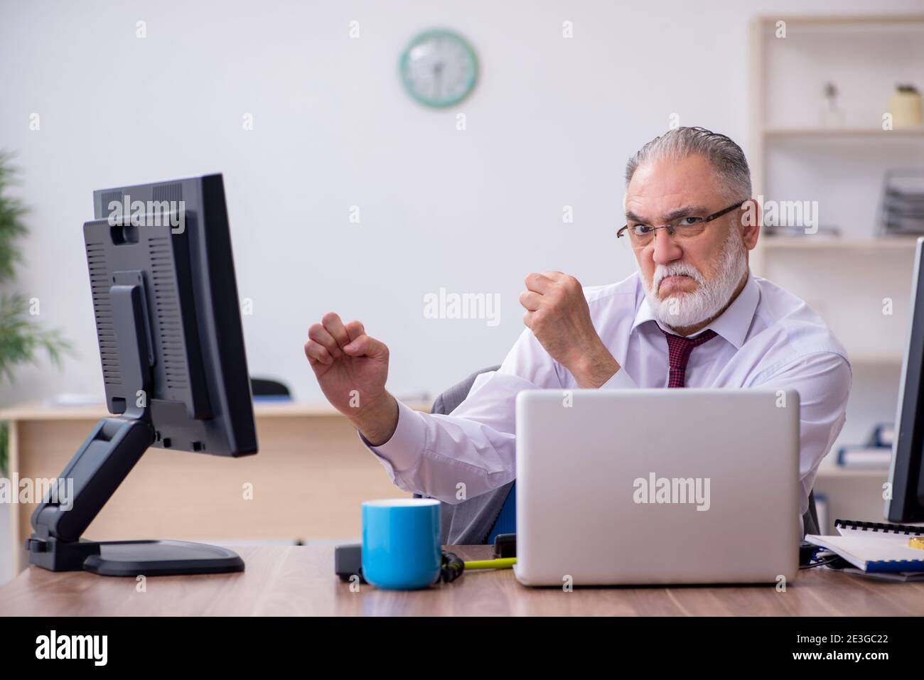 Old boss sitting at desktop in the office Stock Photo - Alamy
