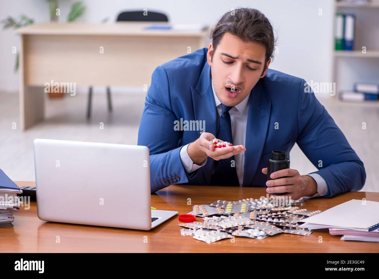 Sick male employee suffering at workplace Stock Photo - Alamy