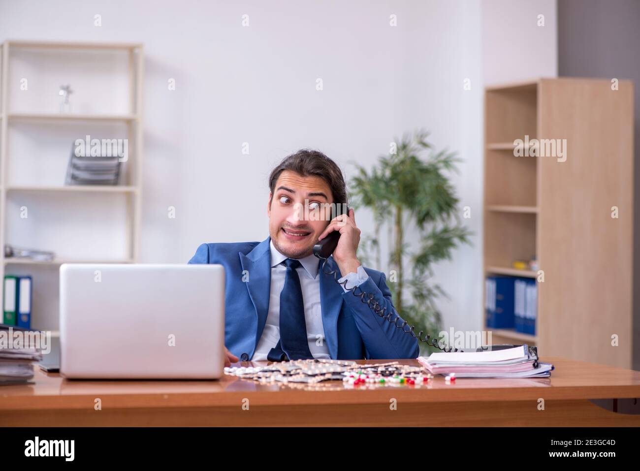 Sick male employee suffering at workplace Stock Photo - Alamy