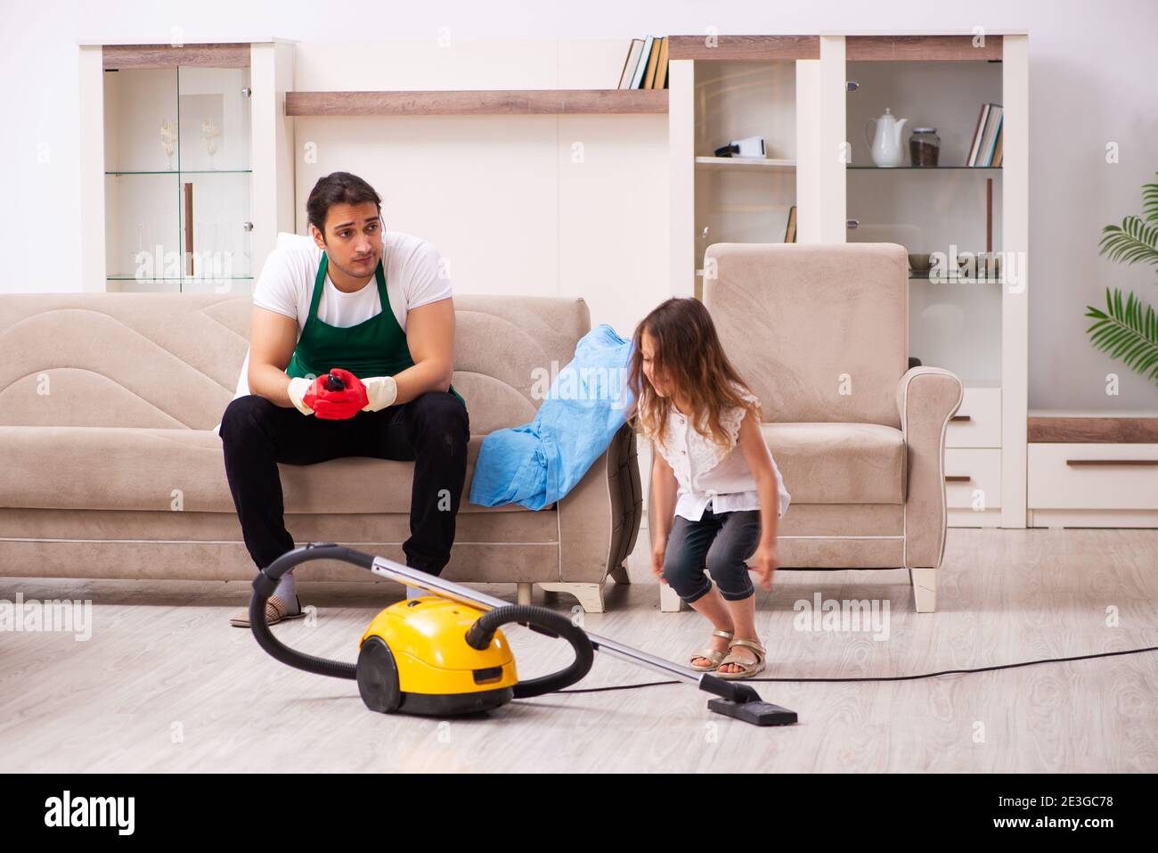 Young contractor cleaning the house with his small daughter Stock Photo ...