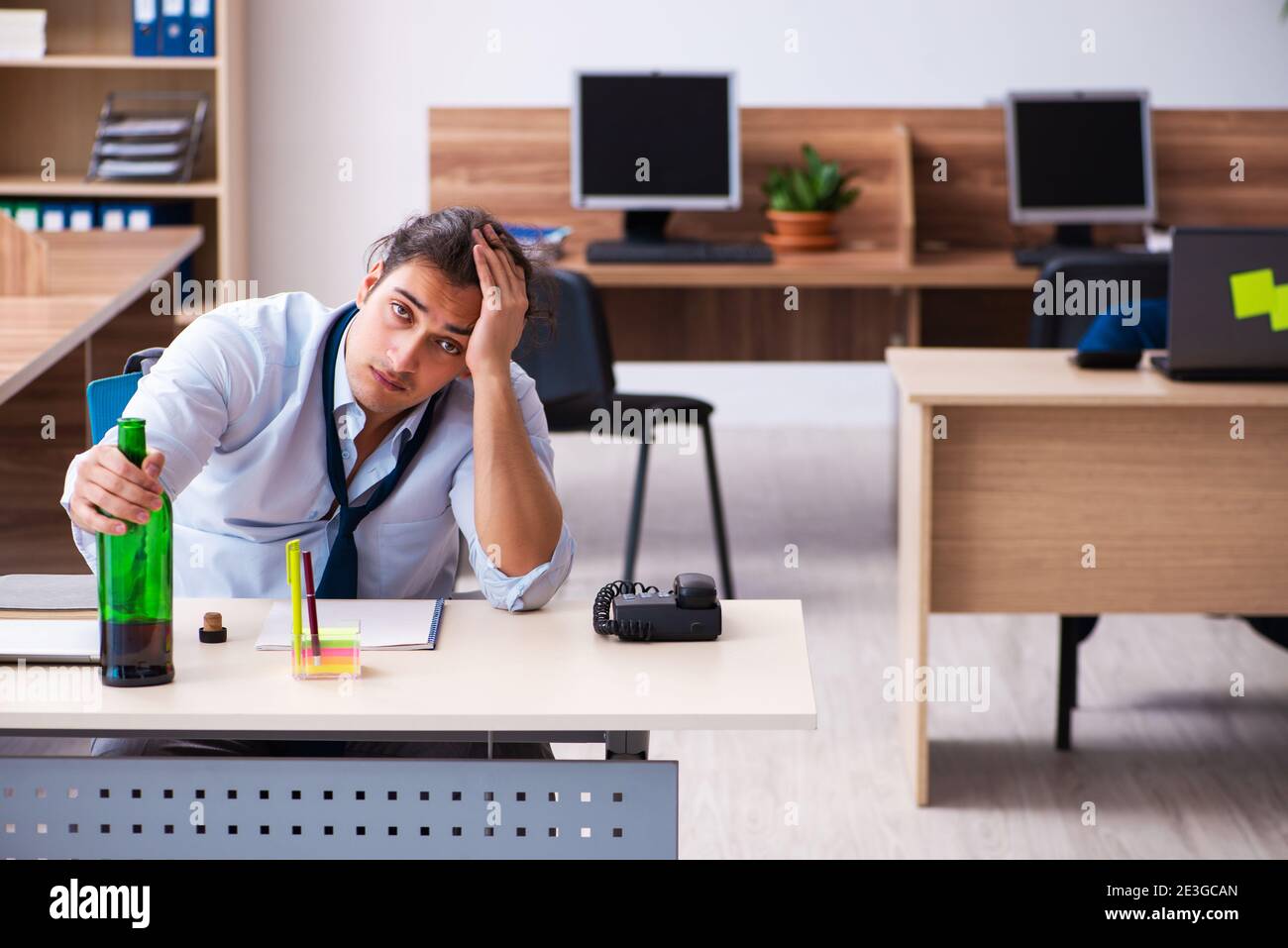 Male employee drinking alcohol at workplace Stock Photo - Alamy