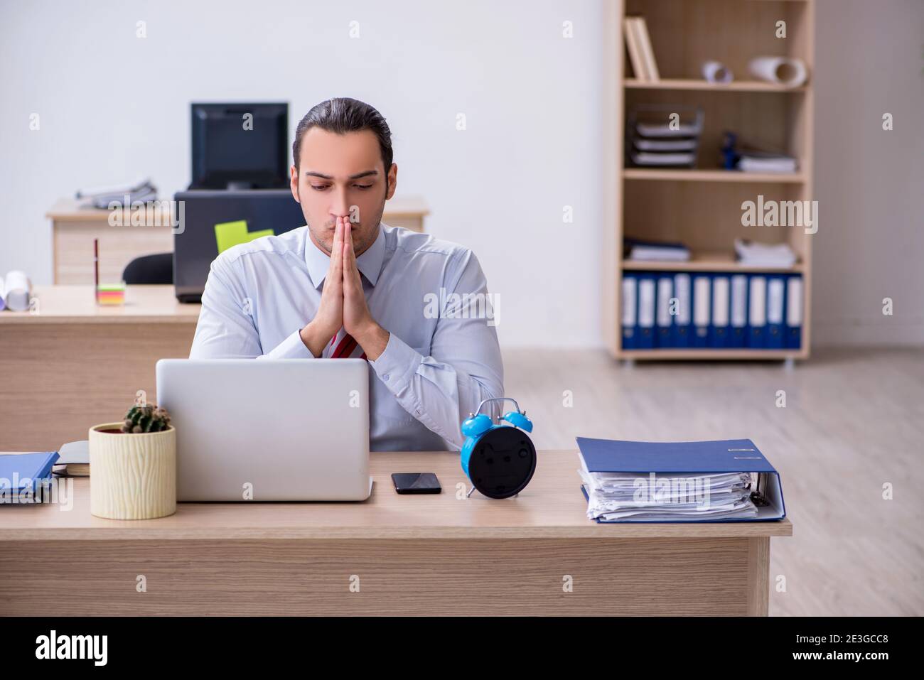 Male employee in time management concept Stock Photo - Alamy