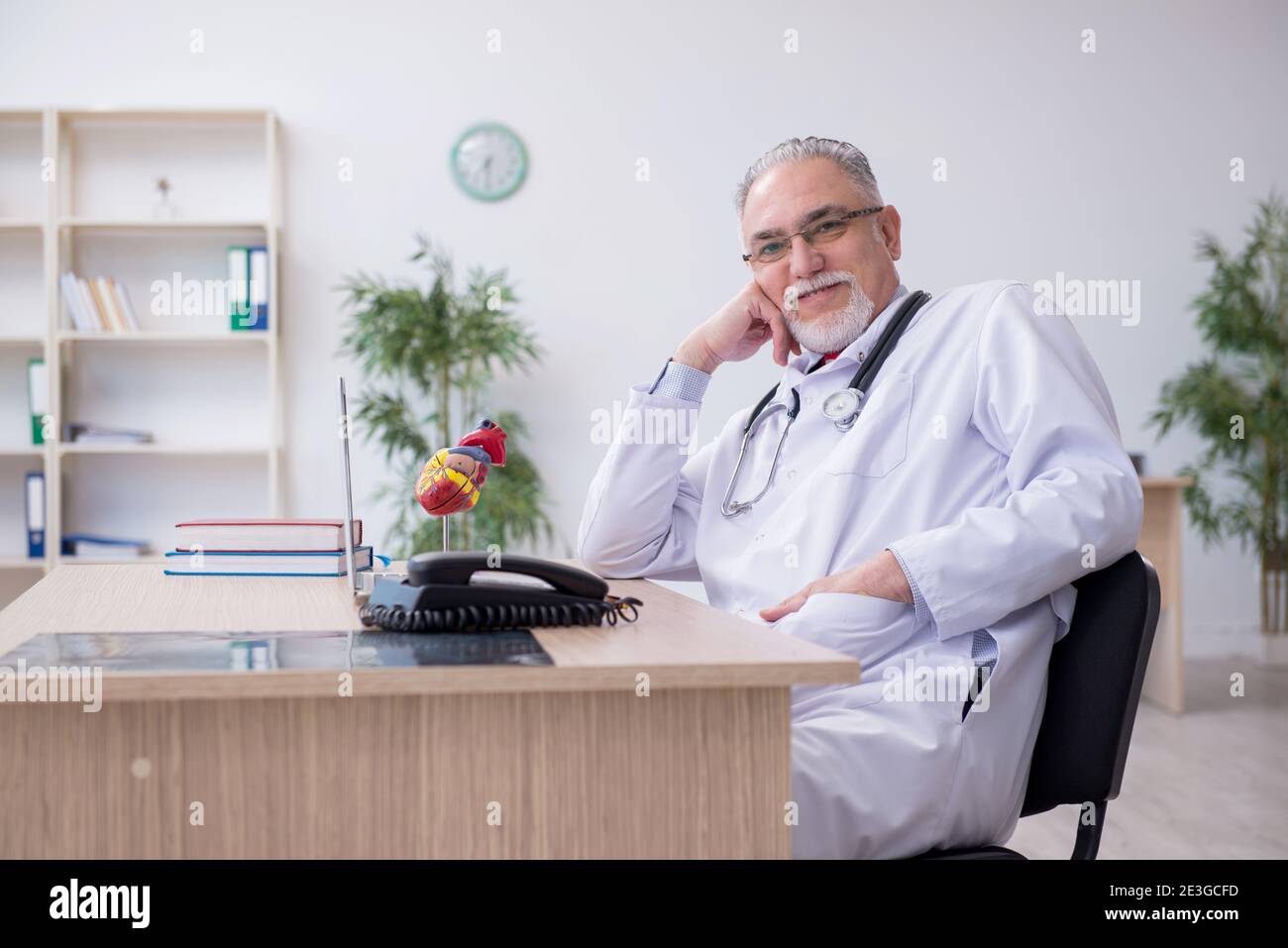 Old male doctor cardiologist working in clinic Stock Photo - Alamy