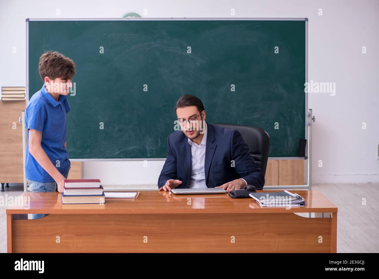 Male teacher and schoolboy in the classroom Stock Photo - Alamy