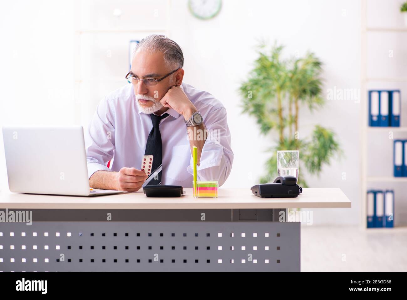 Old sick employee suffering at the workplace Stock Photo - Alamy