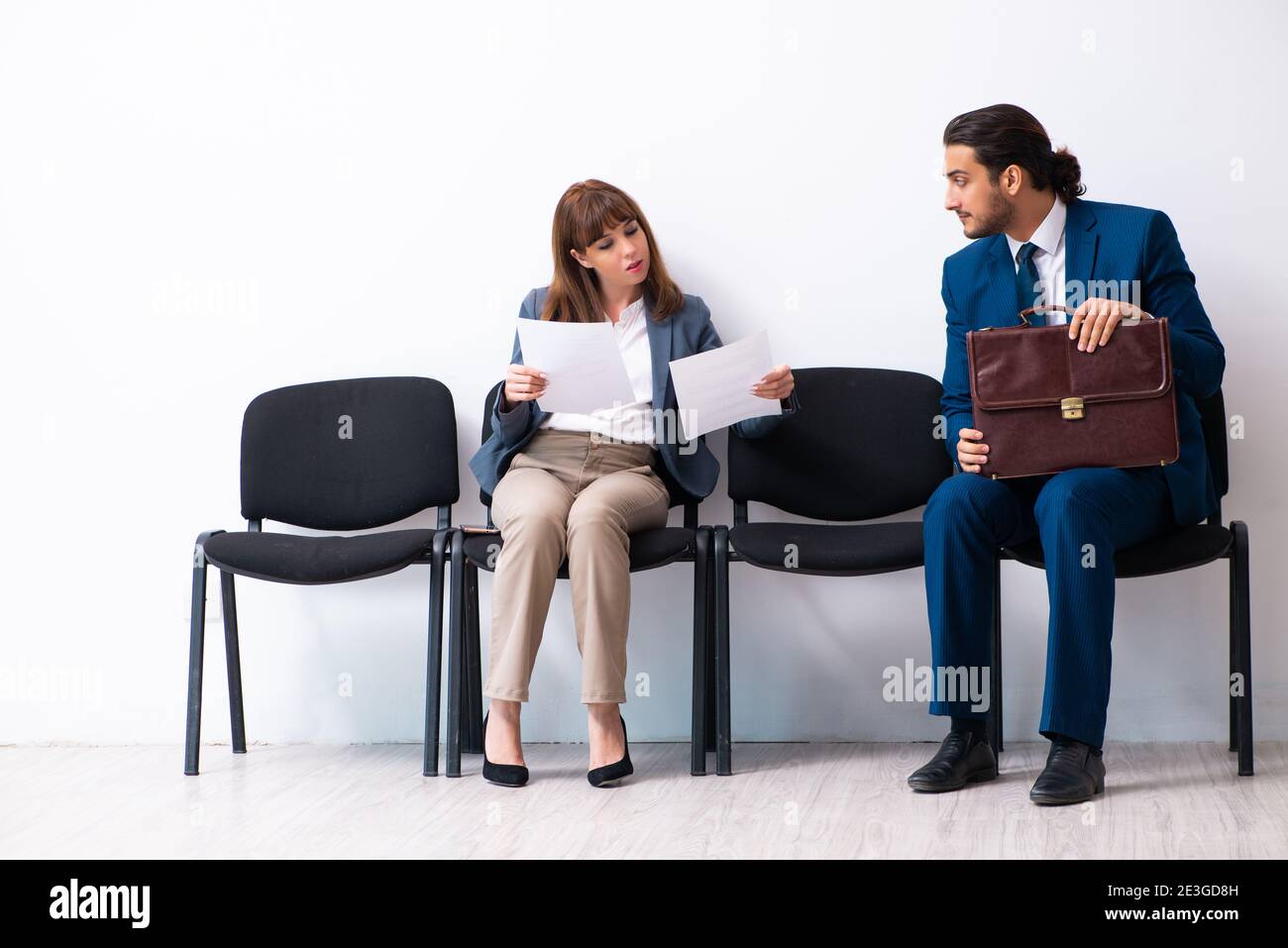 Businessman and businesswoman waiting for an interview at hall Stock ...