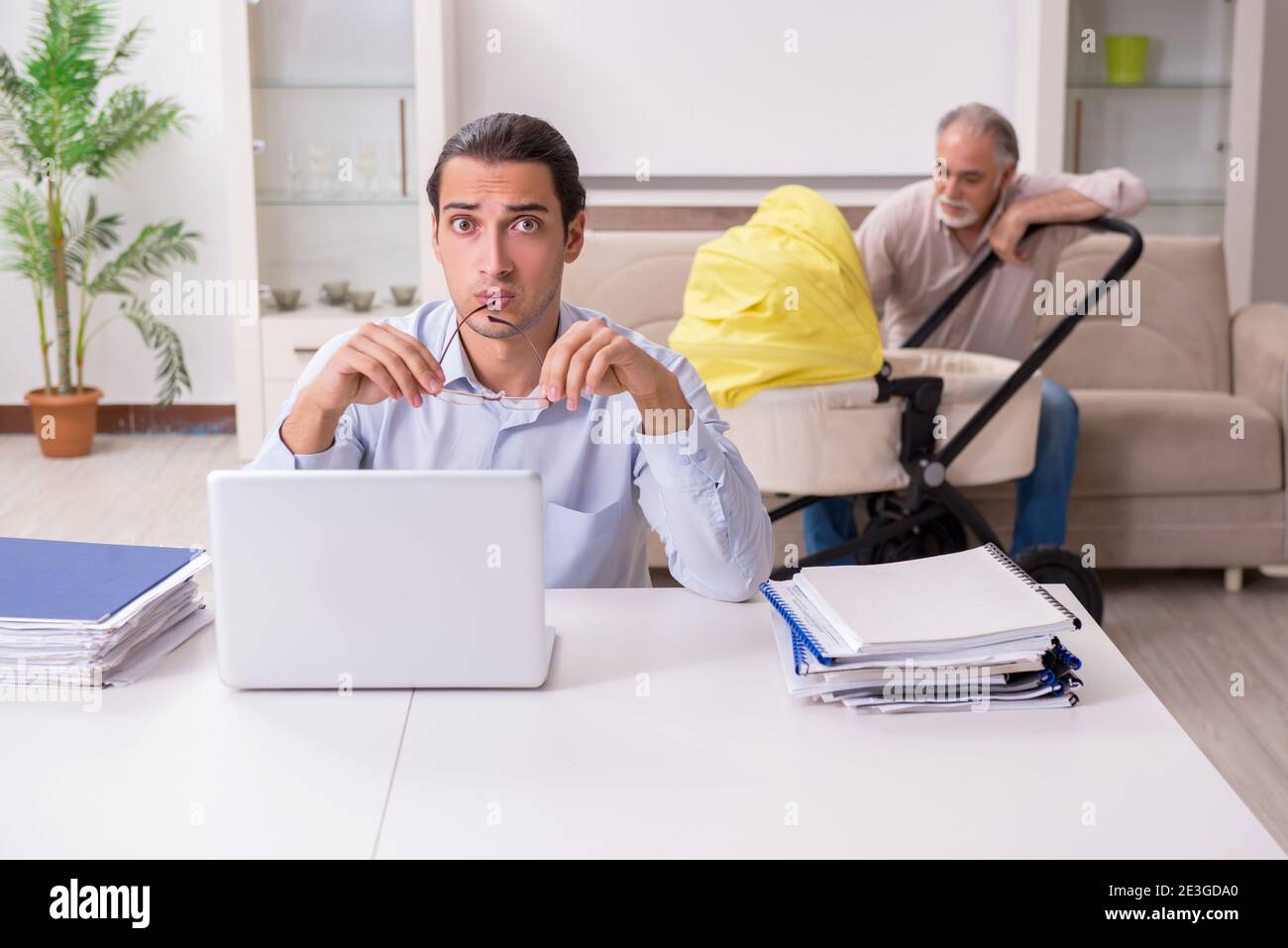 Old grandfather looking after newborn at home Stock Photo - Alamy