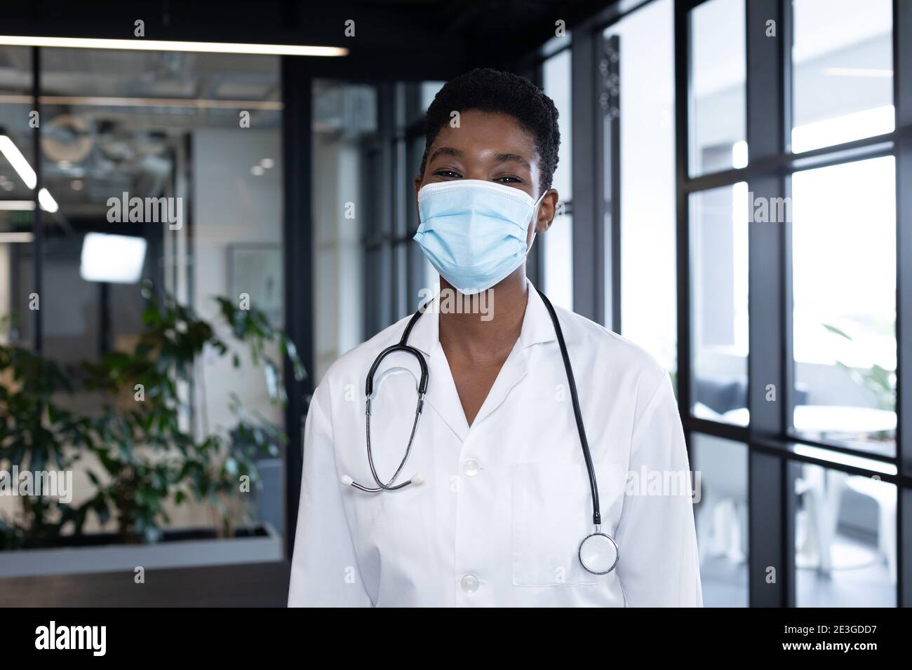 Mixed race female doctor standing looking at the camera and smiling ...