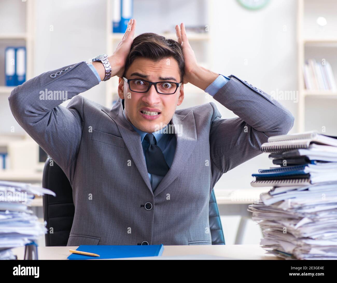 The overloaded with work employee under paperwork burden Stock Photo ...
