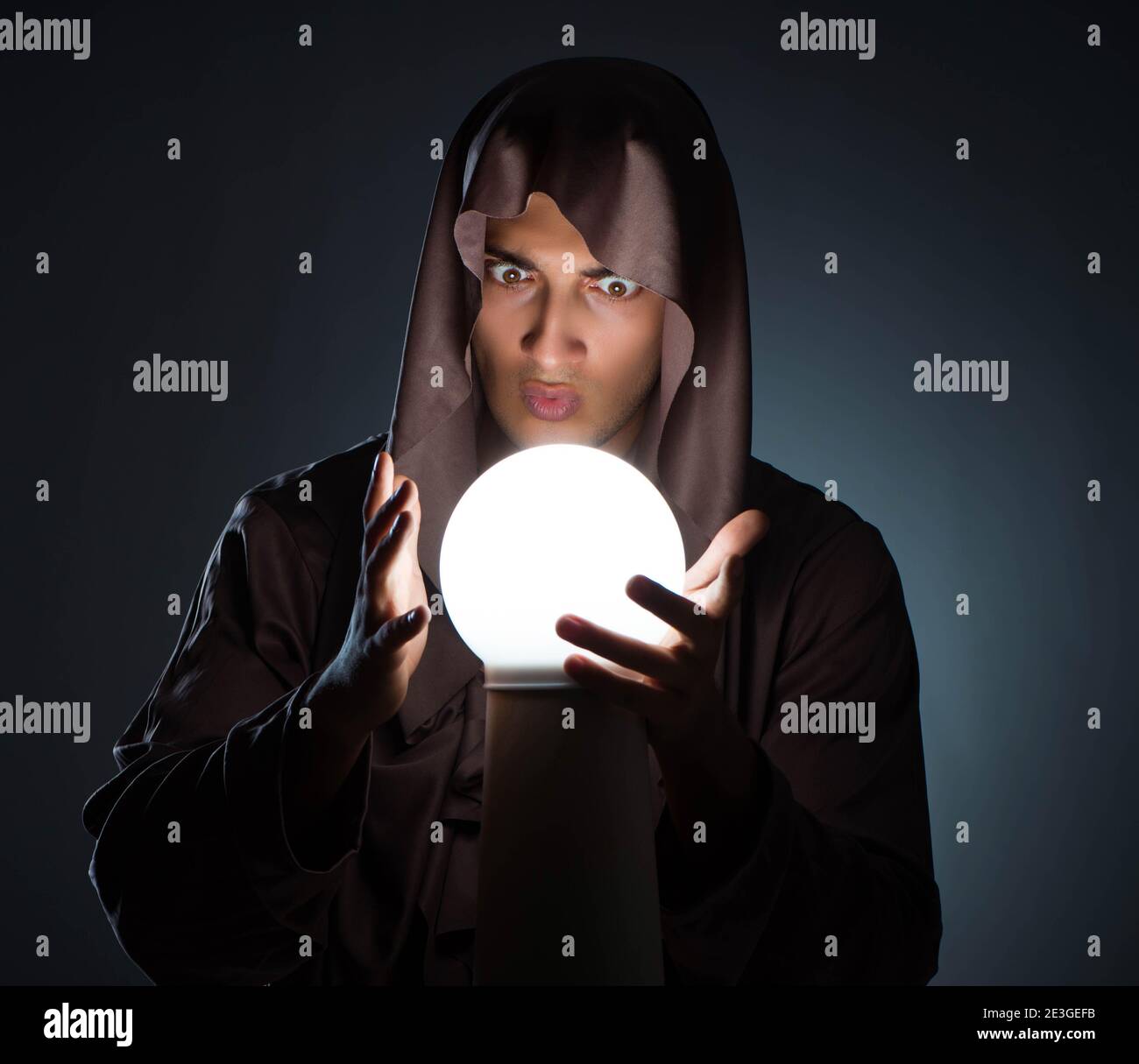 The young wizard with crystal ball in dark room Stock Photo - Alamy