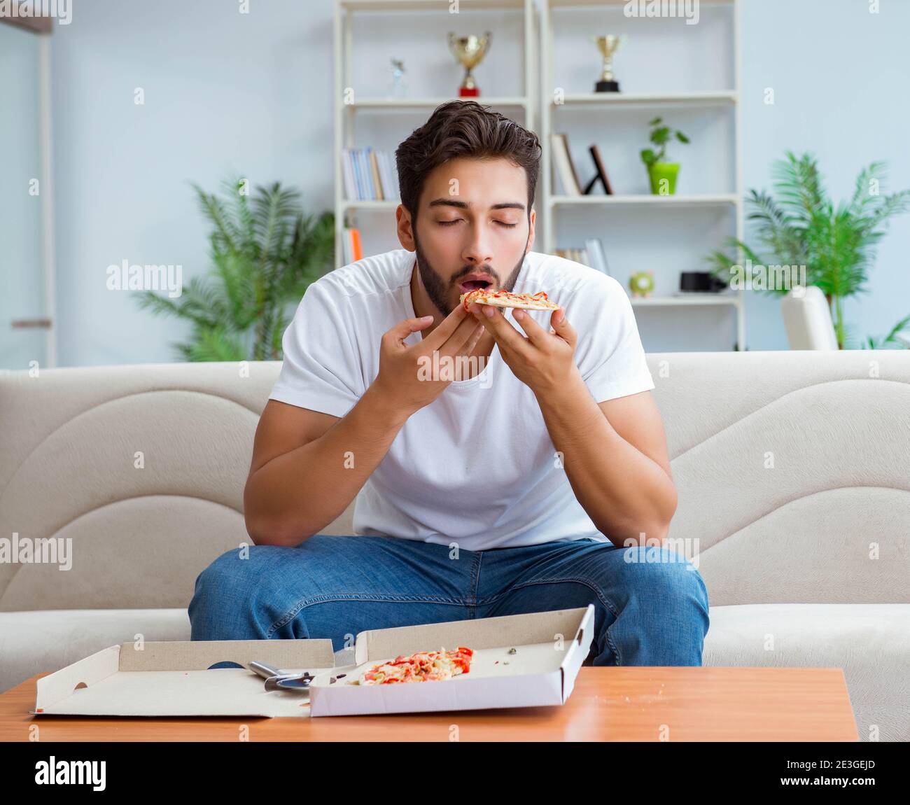 The man eating pizza having a takeaway at home relaxing resting Stock ...