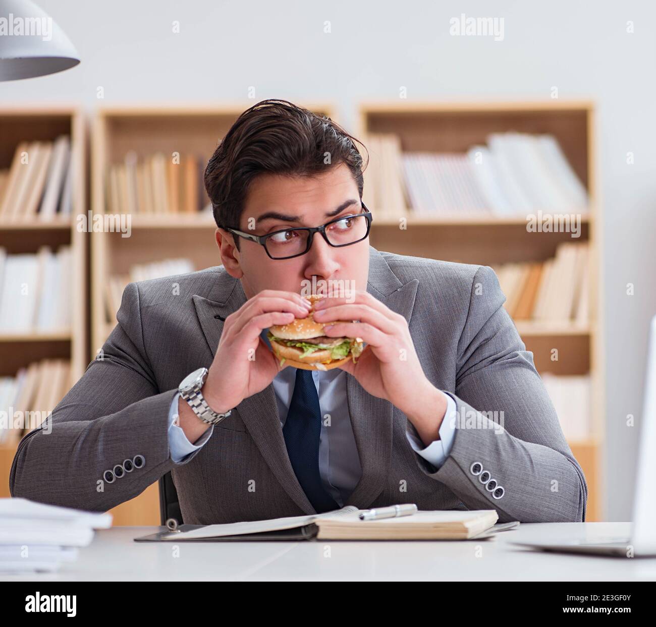 The hungry funny businessman eating junk food sandwich Stock Photo - Alamy