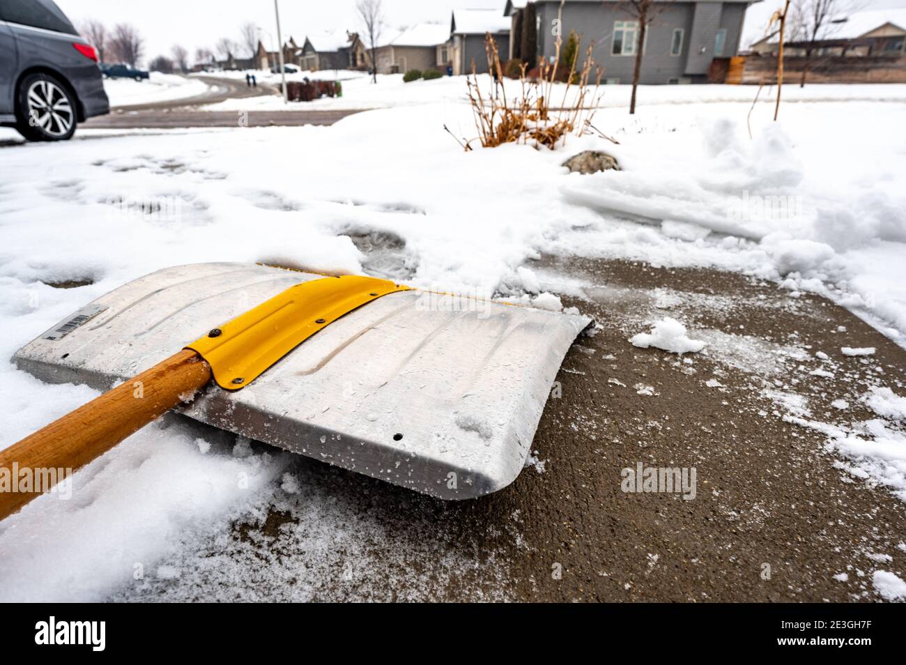 Snow removal manually with a long handled shovel Stock Photo - Alamy