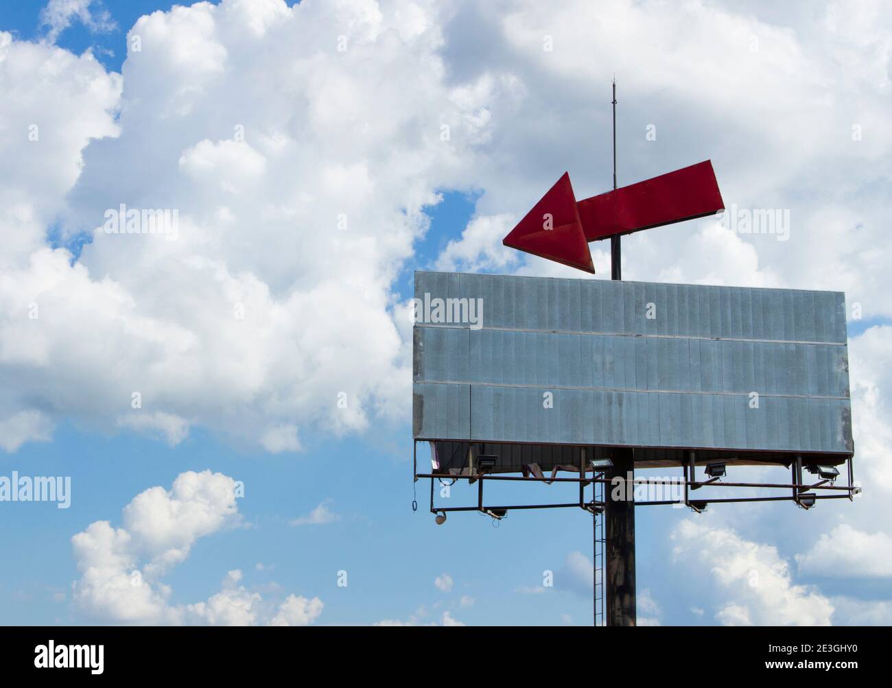 Blank billboard with giant red arrow on the top pointing to the ground ...