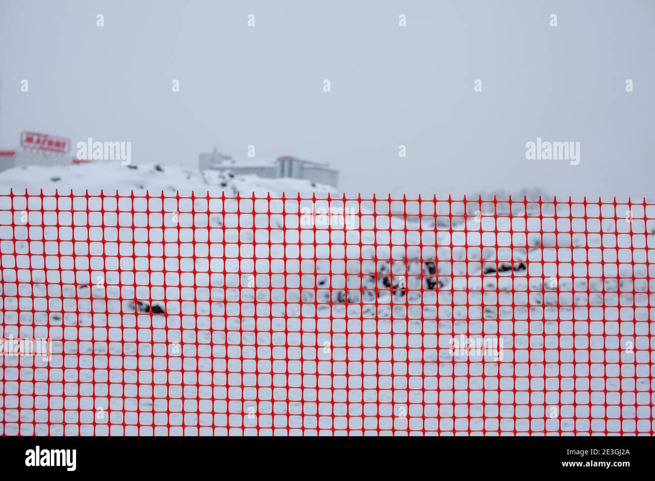 Plastic red safety net for construction site. Fencing repair work on ...