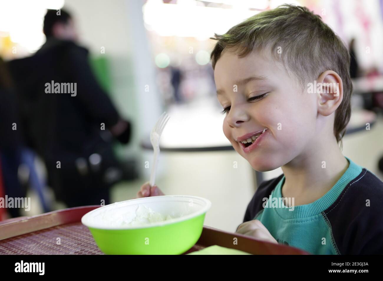 Smiling kid eating meat dumplings in the fast food area Stock Photo - Alamy