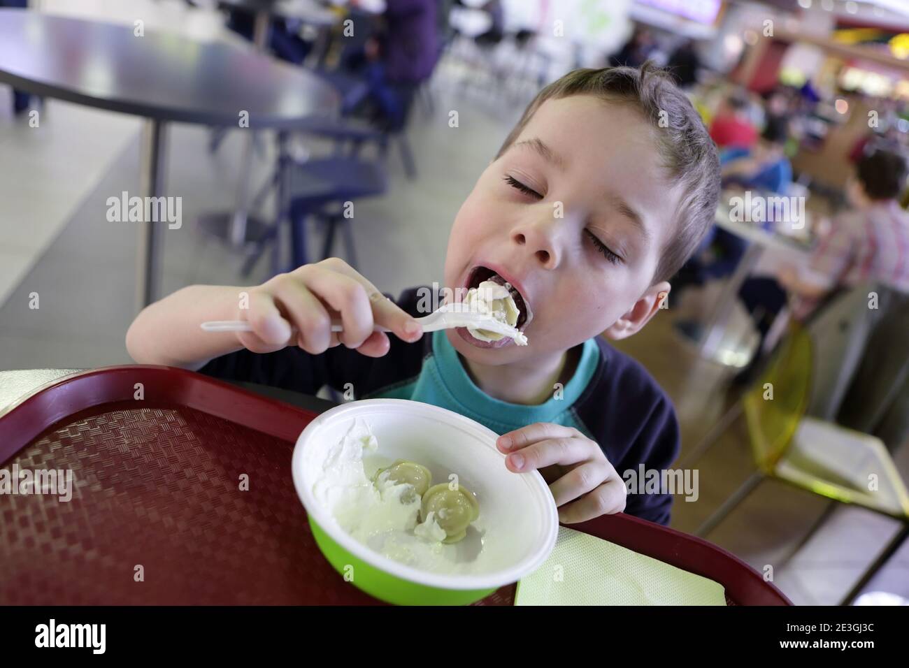 Boy eating meat dumplings in the fast food area Stock Photo - Alamy