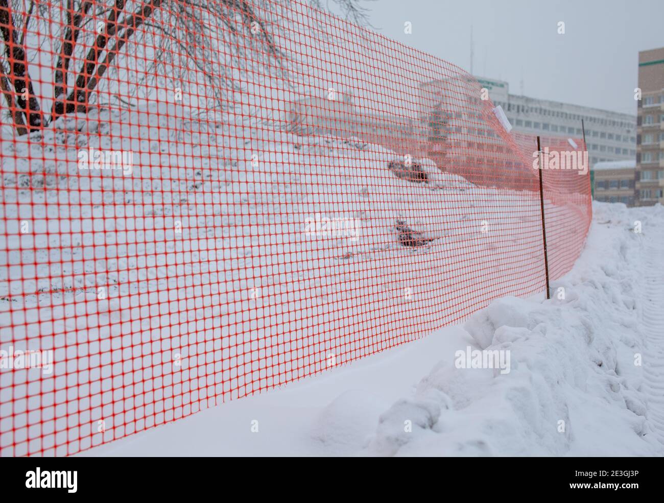 Plastic red safety net for construction site. Fencing repair work on ...