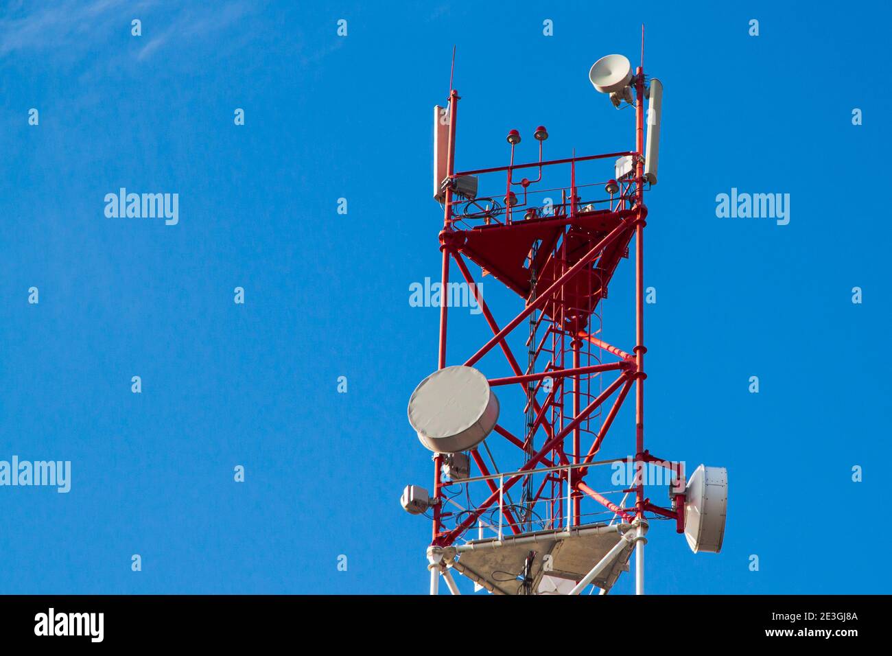 4G 5G cellular repeaters against a blue sky. Mobile phone Telecommunication Radio antenna Tower ...