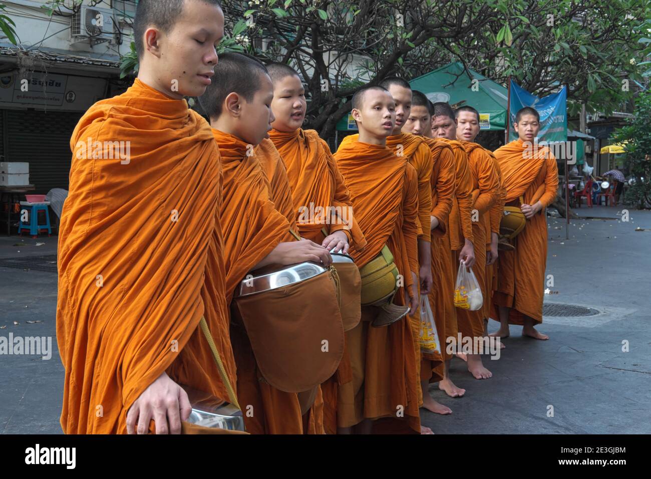Novice Buddhist monks with their alms bowls on their traditional ...