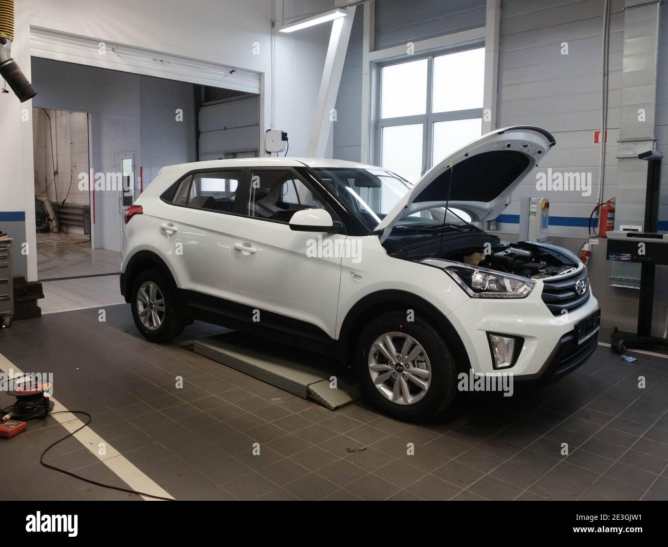 Hyundai Creta at car service. White SUV with open engine hood at garage ...
