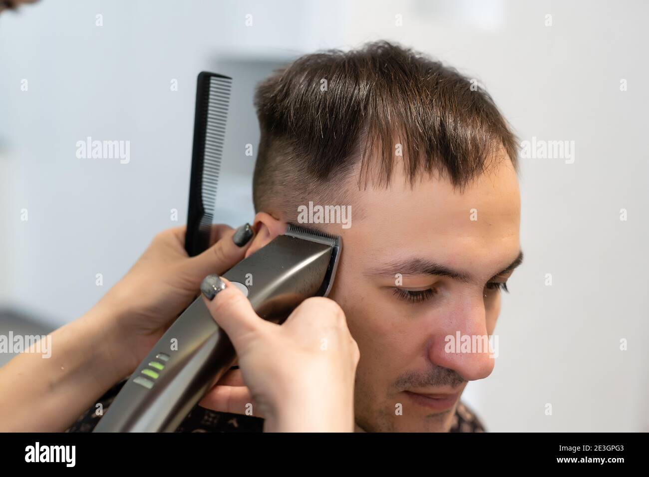 Barber cutting hair with clipper Stock Photo - Alamy