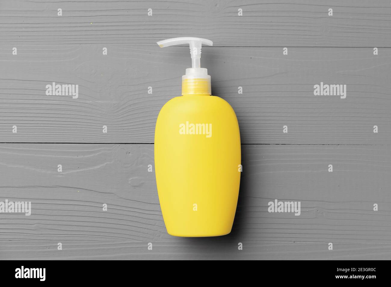 Yellow cosmetic container on gray background top view Stock Photo - Alamy