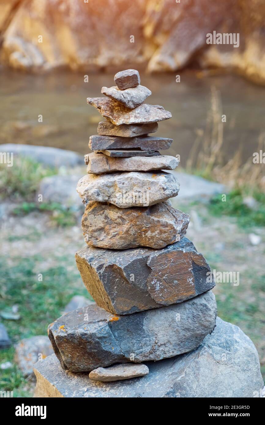 Close-up of a pyramid of stones on the background of the river and ...