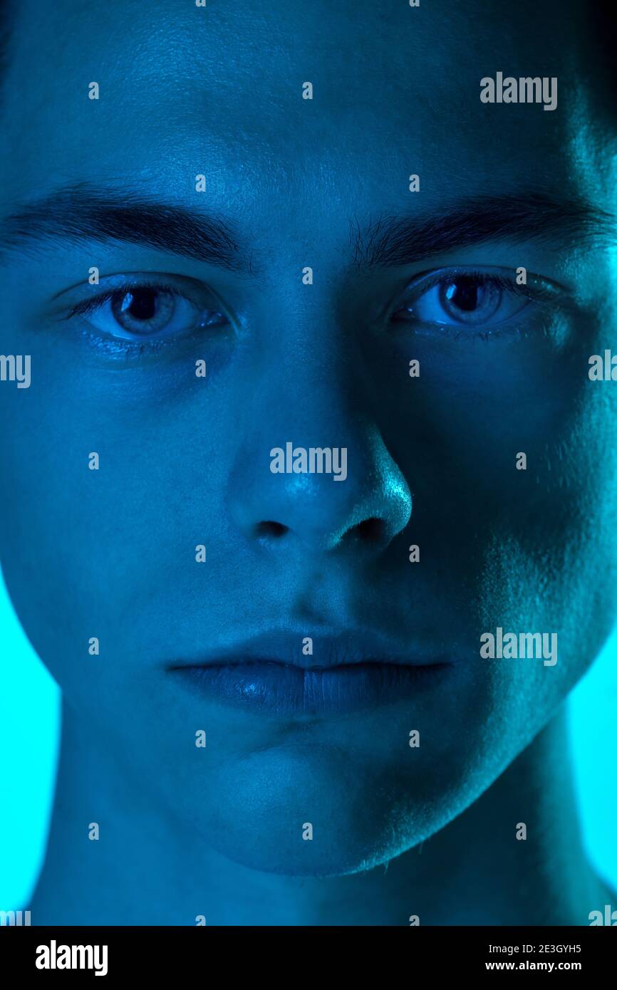 Skin. Handsome caucasian man's portrait isolated on blue studio ...