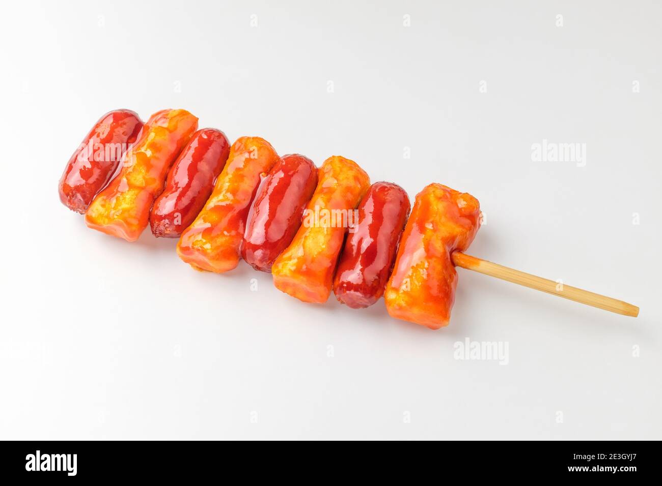 Sausage rice cake skewers on a white background Stock Photo - Alamy