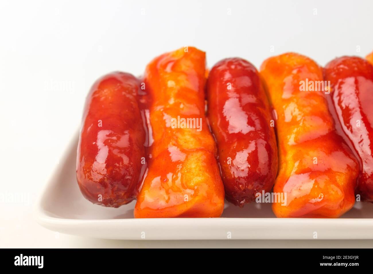 Sausage rice cake skewers on a white background Stock Photo - Alamy