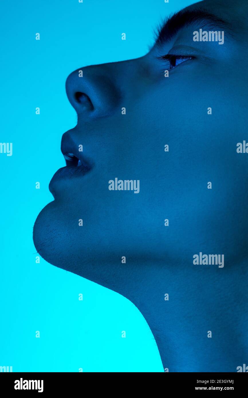 Cheeks. Handsome caucasian man's portrait isolated on blue studio ...
