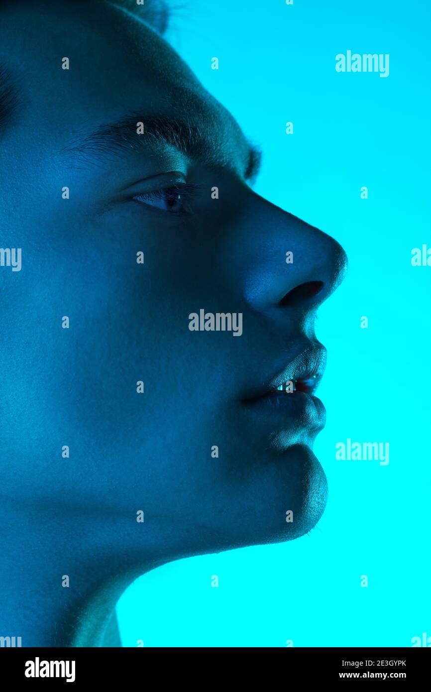 Cheeks. Handsome caucasian man's portrait isolated on blue studio ...