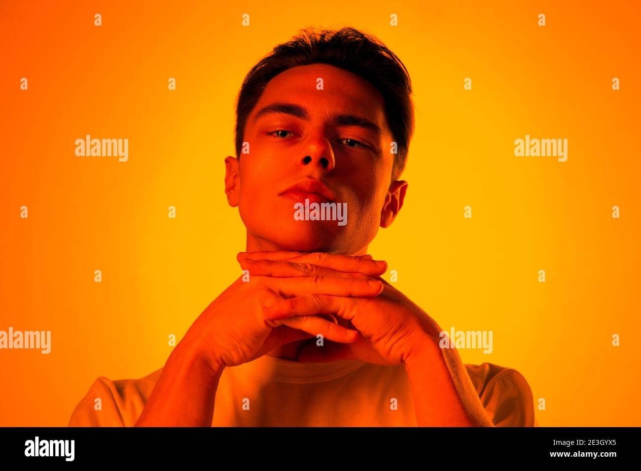 Busy. Handsome caucasian man's portrait isolated on orange studio ...