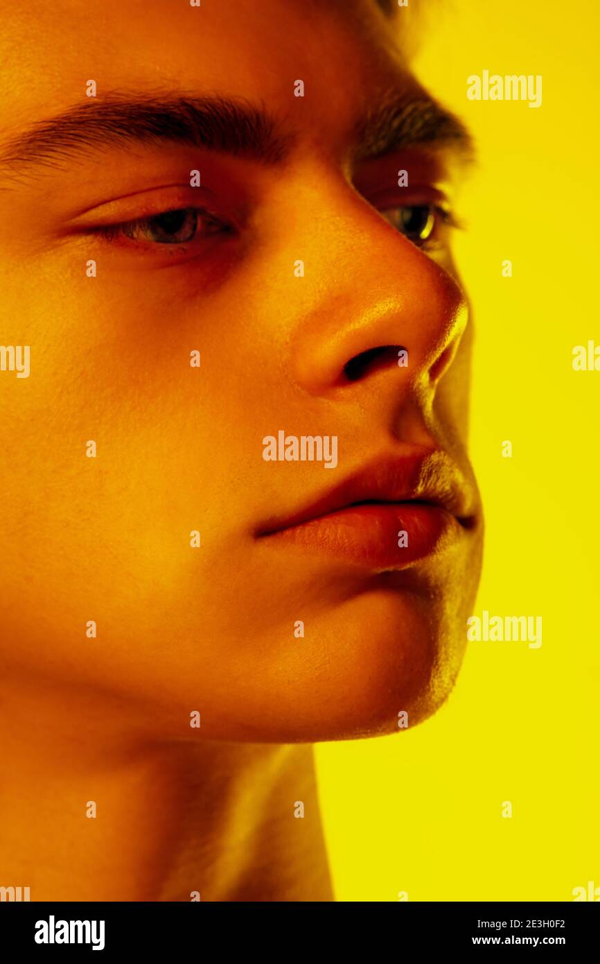 Cheeks. Handsome caucasian man's portrait isolated on orange studio ...