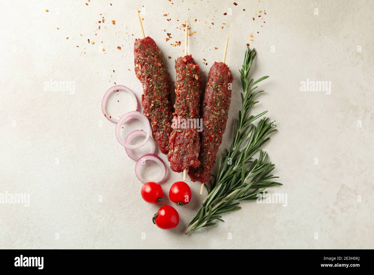 Raw lula kebab, herbs and spices on white textured background Stock ...