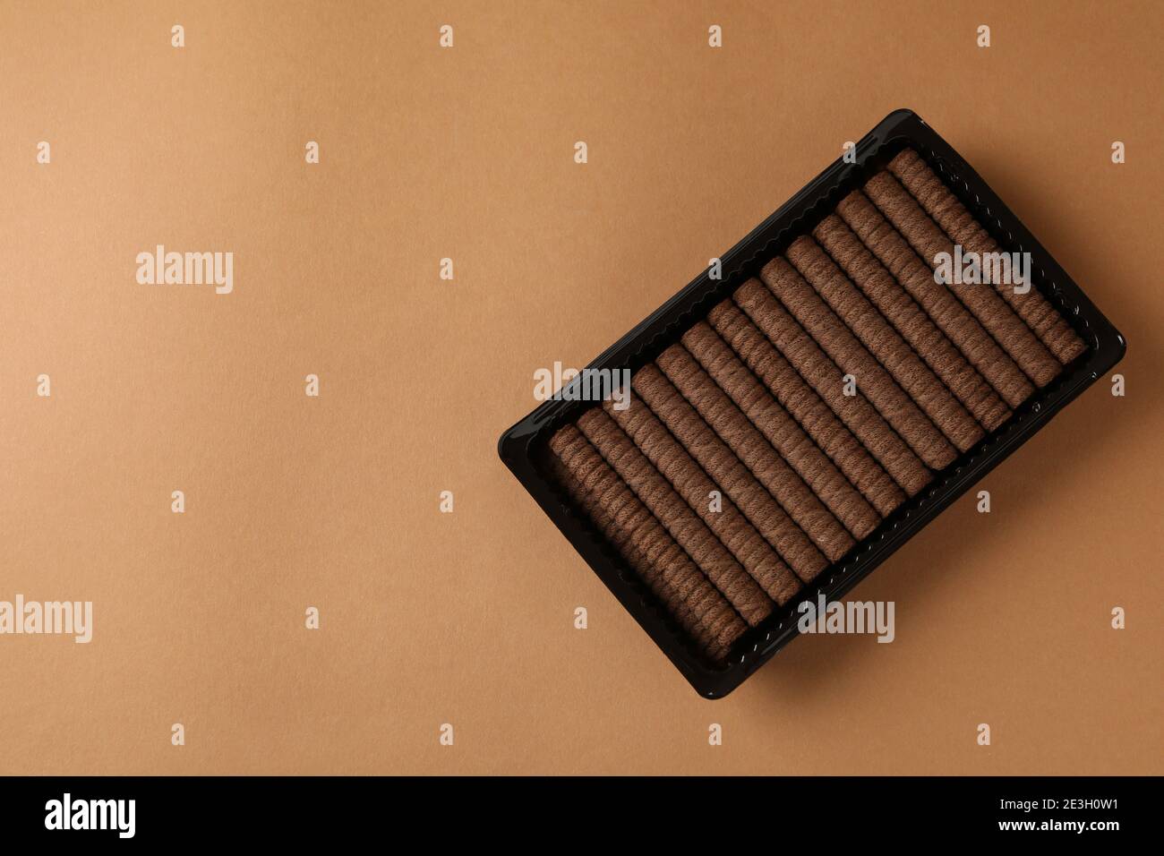 Plastic box with chocolate wafer rolls on brown background Stock Photo ...