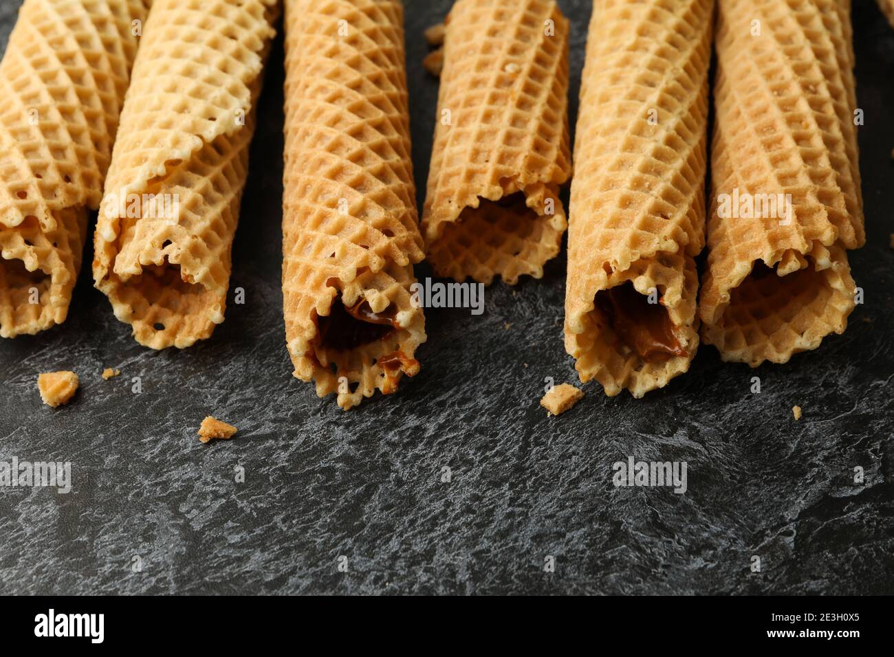 Wafer rolls with condensed milk on black smokey background Stock Photo ...